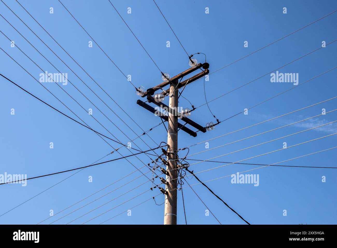 High-voltage wires on the pole three phase closeup on blue sky ...