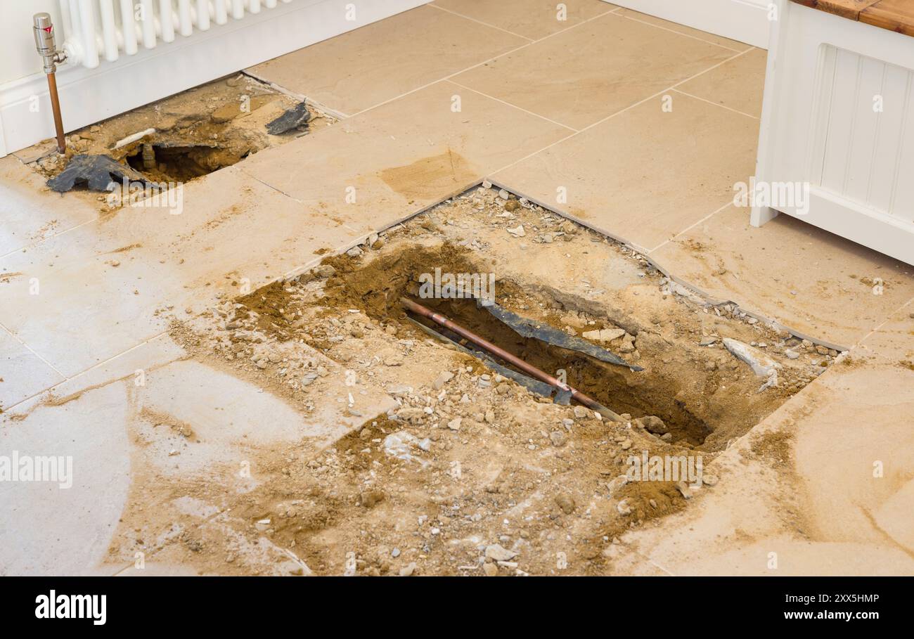 Domestic central heating pipework exposed under a tile floor after ...