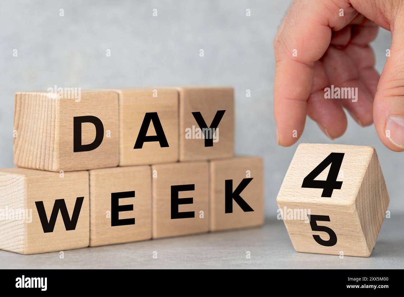 4 day week, Business concept. Hand turning wooden cube from 5 to 4 ...