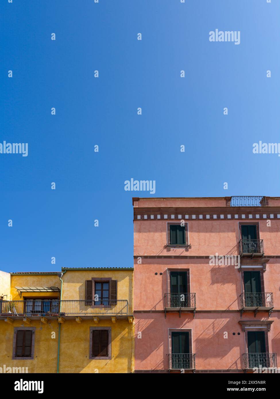 The facades of two adjacent buildings, one red and one yellow, create a ...
