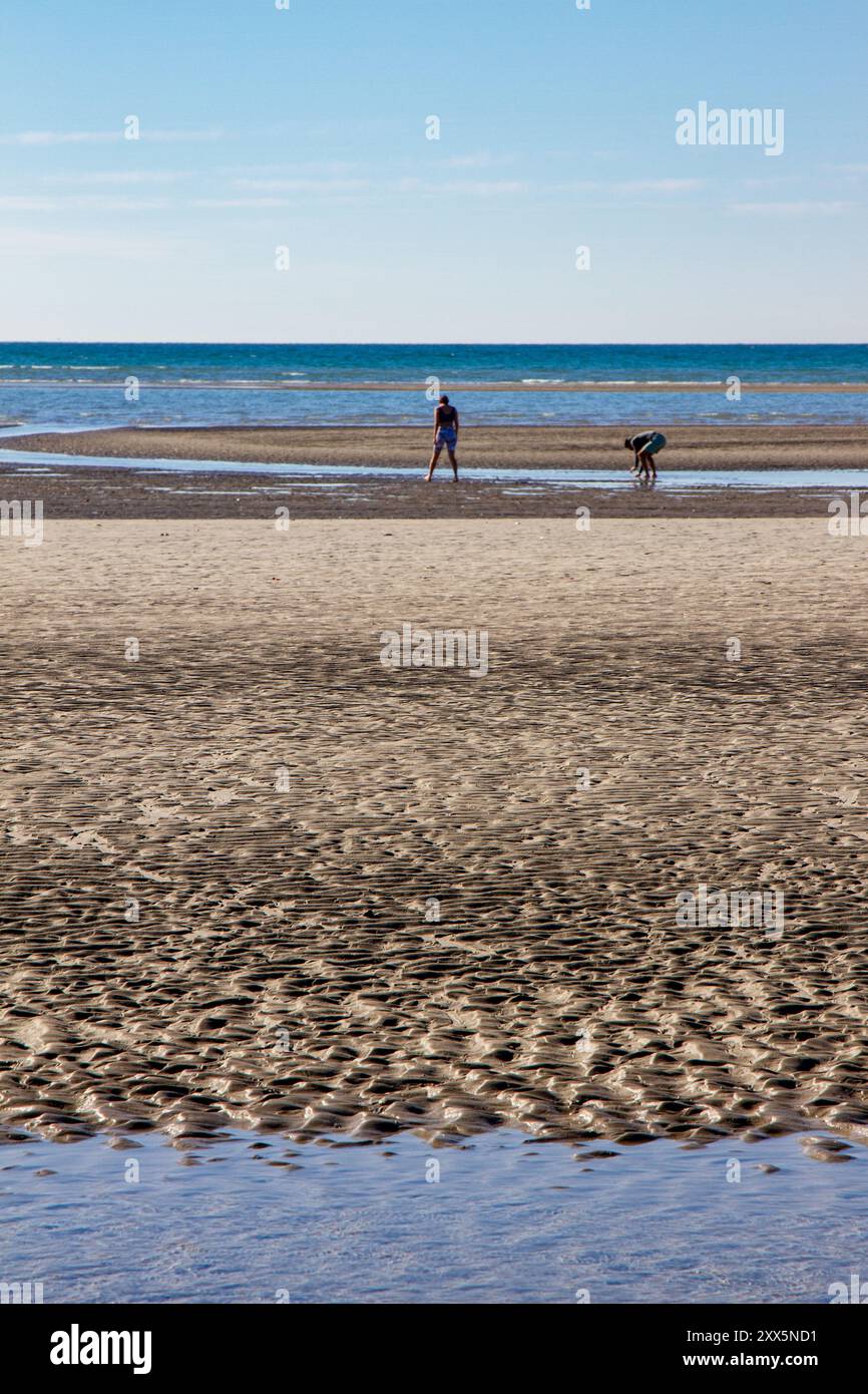 Two people hanging around at the beach. Siblings playing at a virgin ...