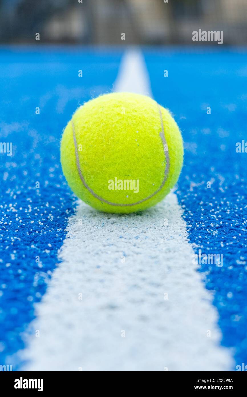 Paddle tennis ball on the center line of a blue paddle tennis court ...