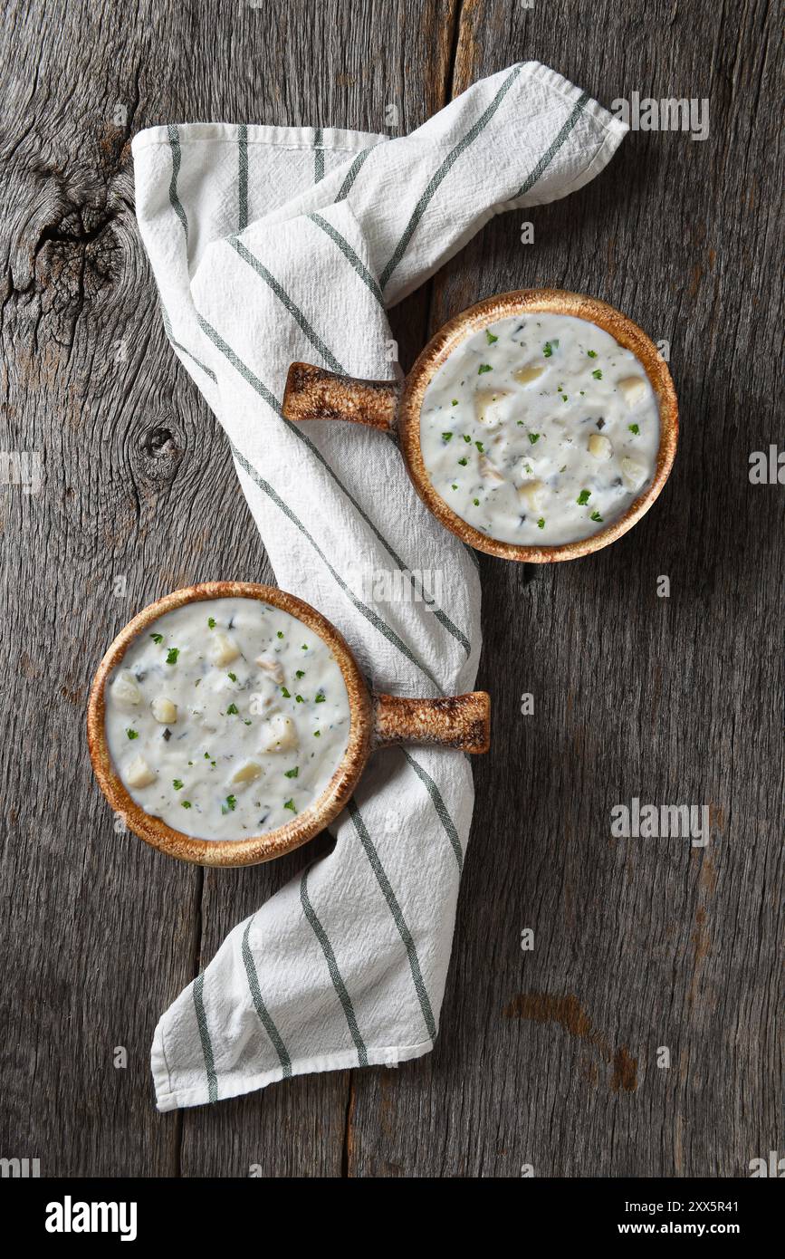 Flat lay with two bowls of homemade Clam Chowder bowls on a rustic wood ...