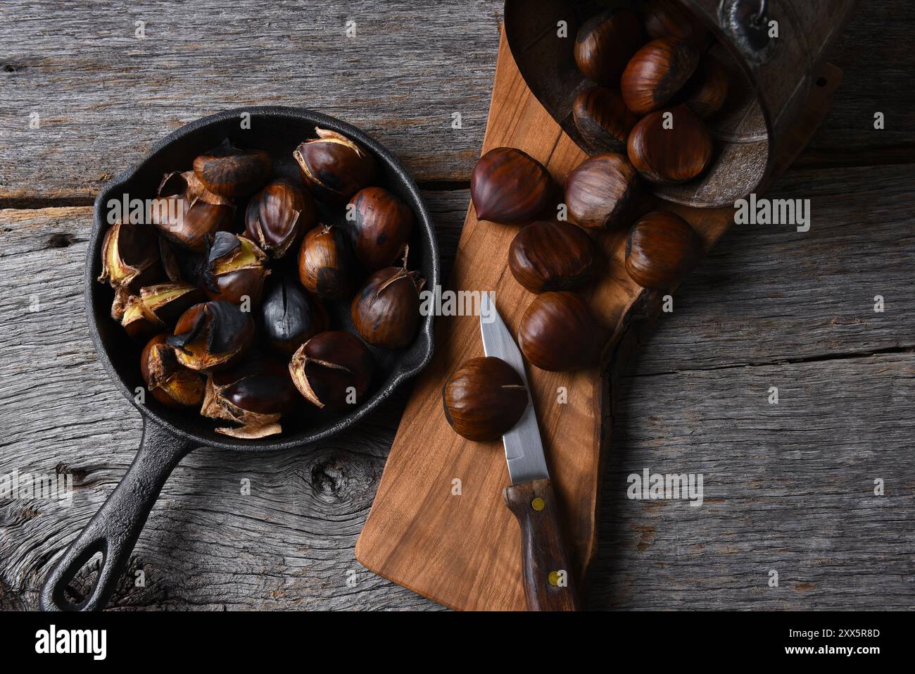 A bucket of fresh chestnuts and a pan full of roasted nuts Stock Photo ...