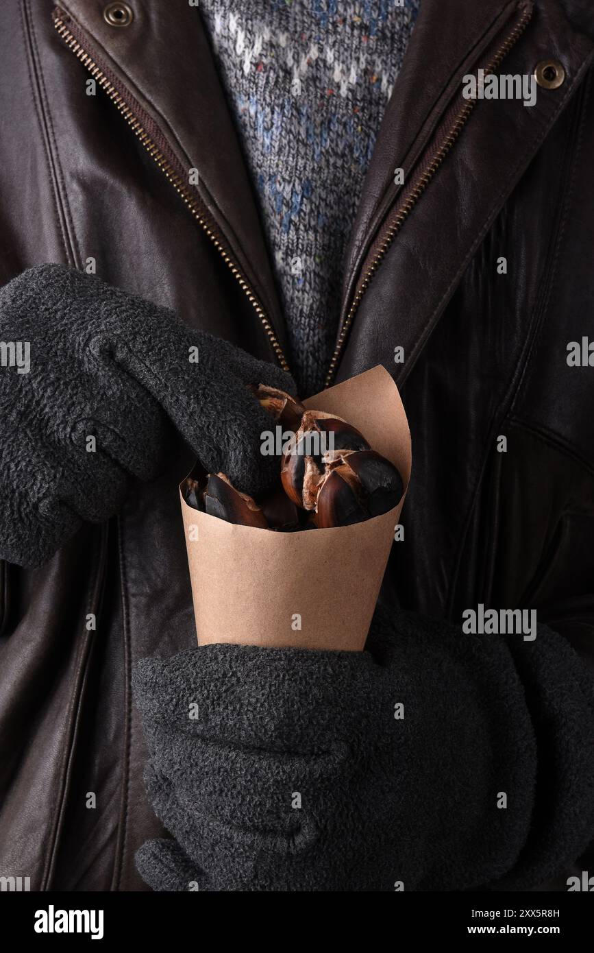 Closeup of a man in sweater and leather jacket holding a brown paper ...