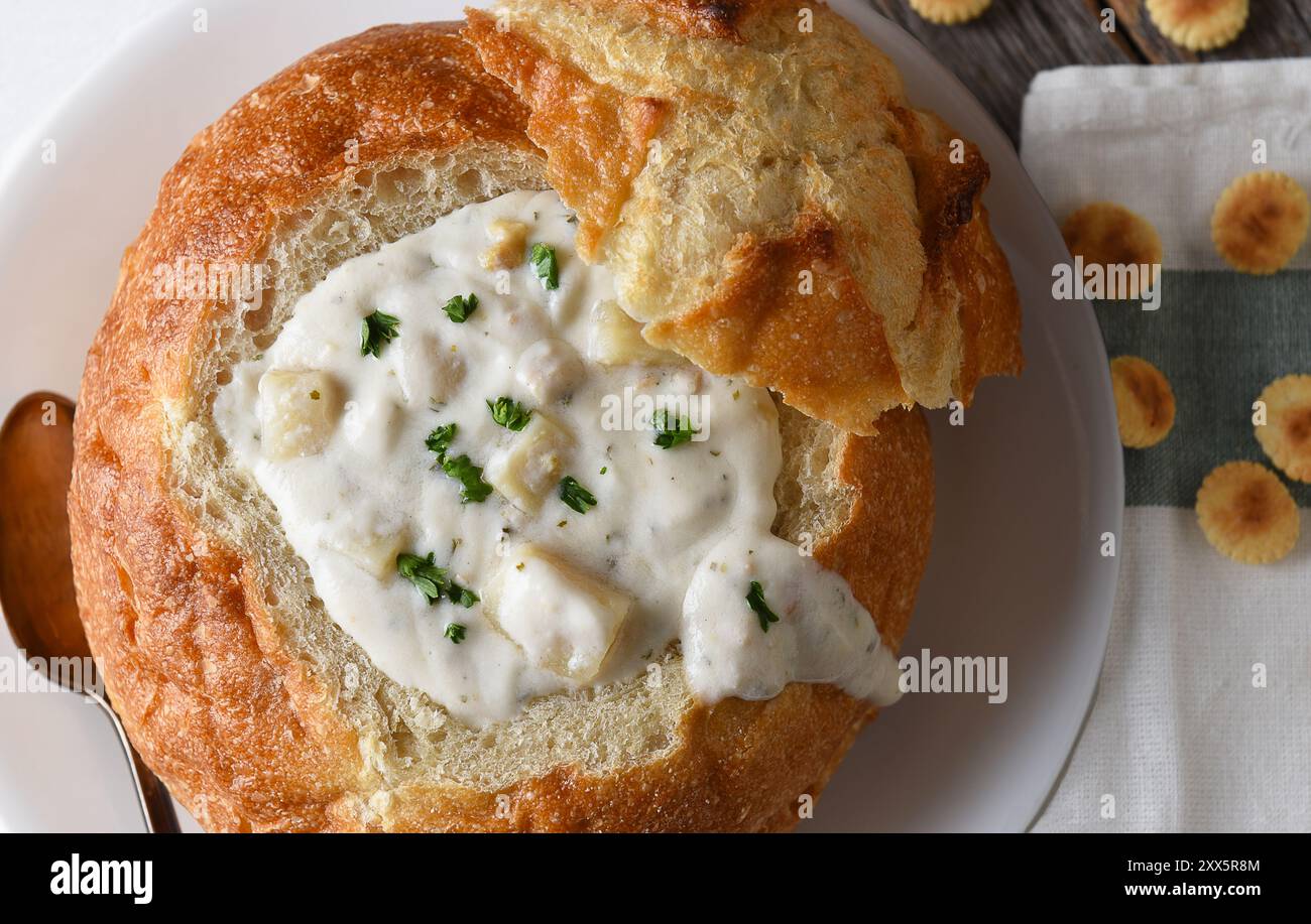 Overhead closeup of a bread bowl of New England Style Clam Chowder with ...