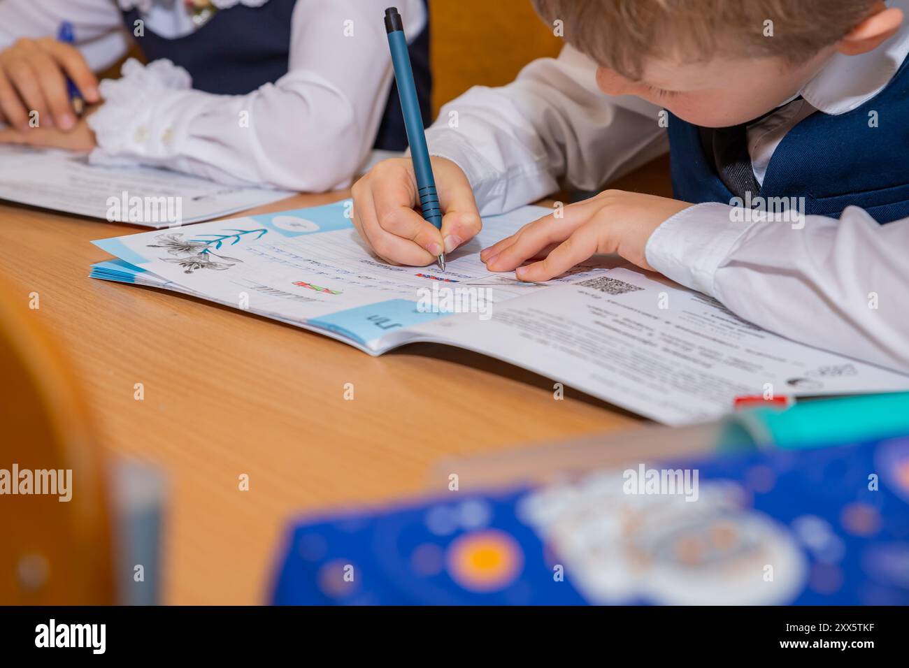 Close-up cropped shot of unrecognizable pupil boy studying at home ...