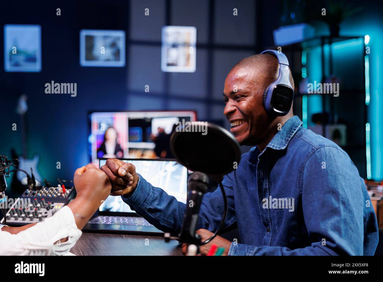 Cheerful male host fist bumps an individual, welcoming the guest on his ...