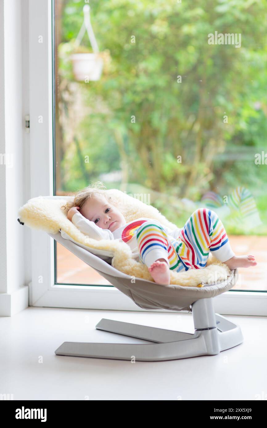 Toddler child in rocking chair. Little girl in pajamas relaxing in ...