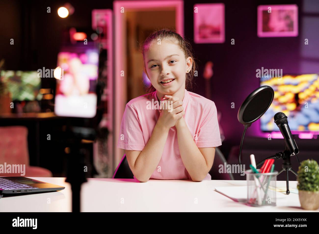 Cheerful child filming room tour inside home studio using cellphone on ...