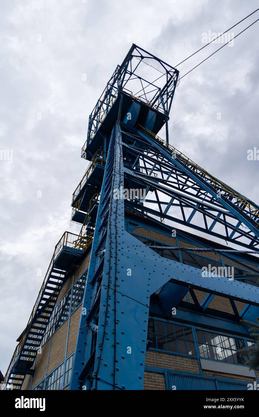 Blue coal mine shaft against cloudy sky with dramatic clouds. Reduction ...