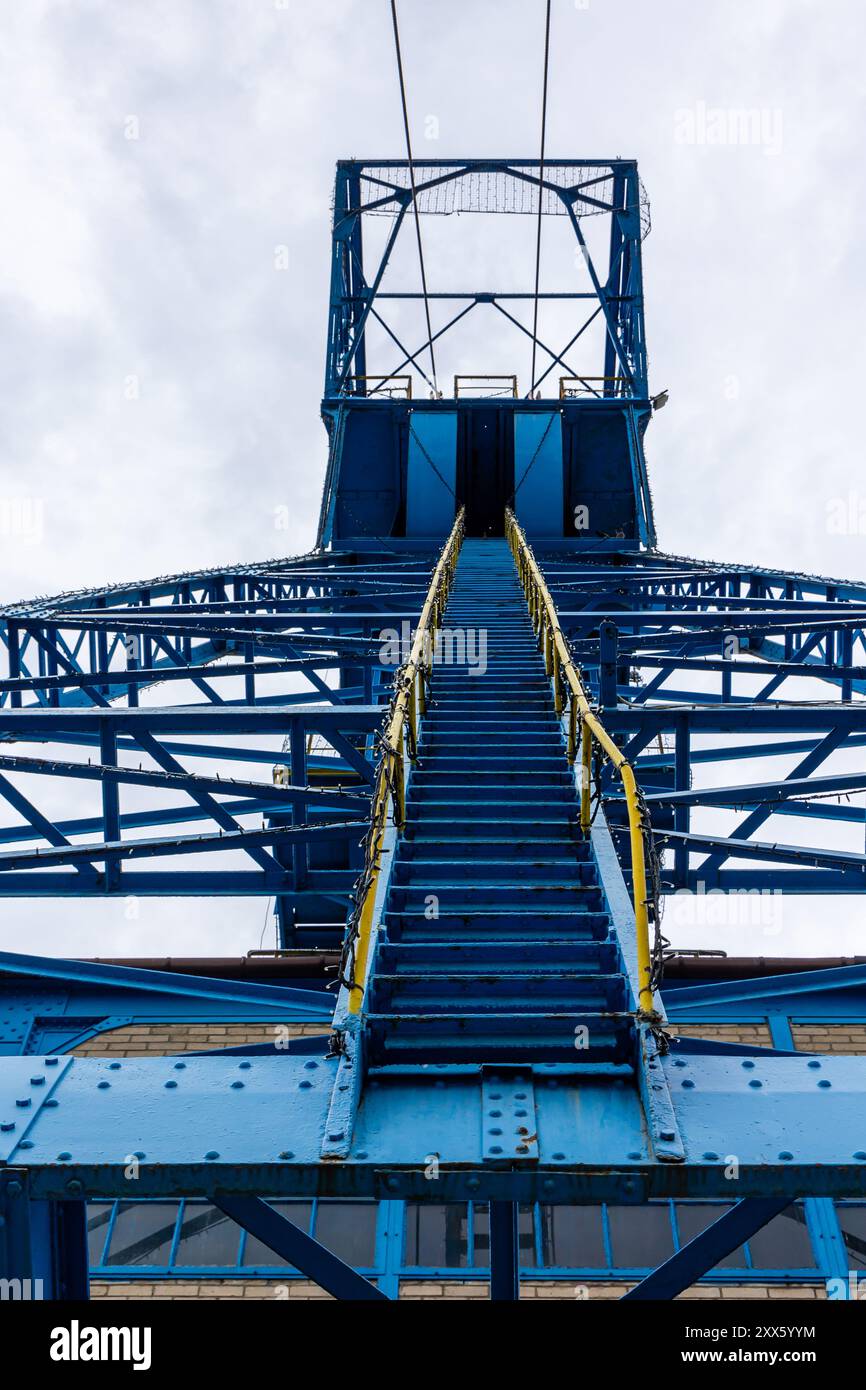 Blue coal mine shaft against cloudy sky with dramatic clouds. Reduction ...