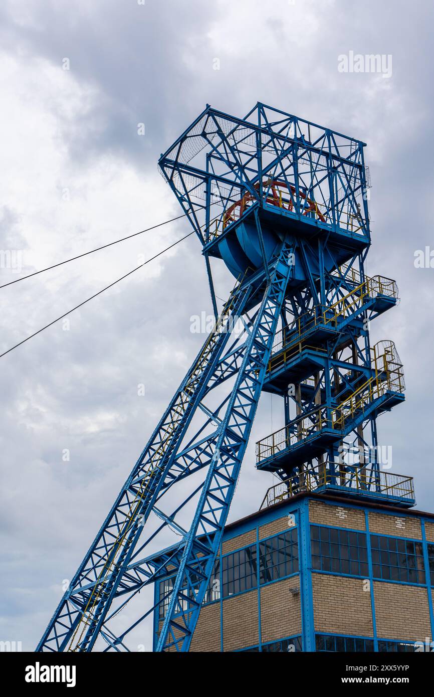 Blue coal mine shaft against cloudy sky with dramatic clouds. Reduction ...