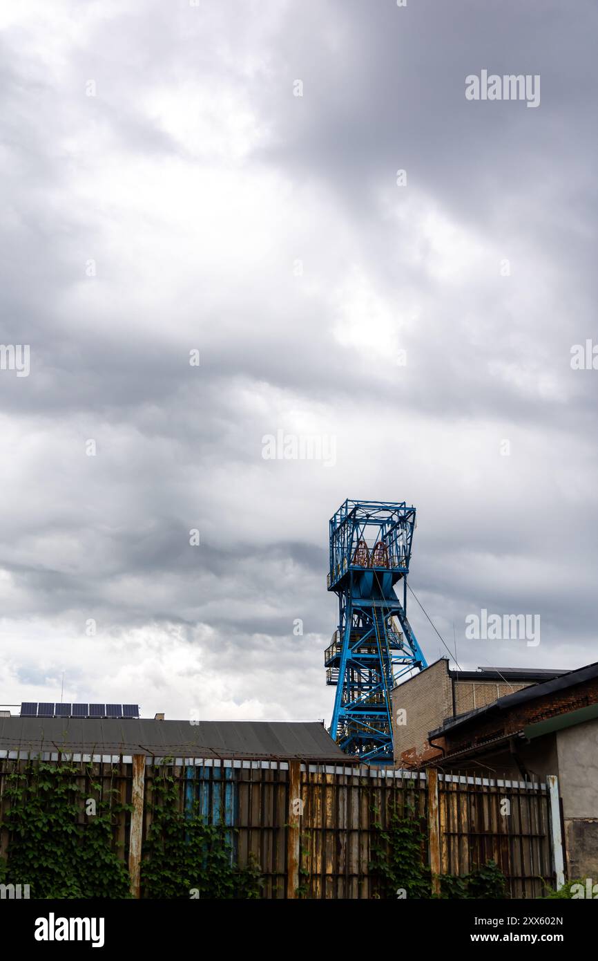 Blue coal mine shaft against cloudy sky with dramatic clouds. Reduction ...