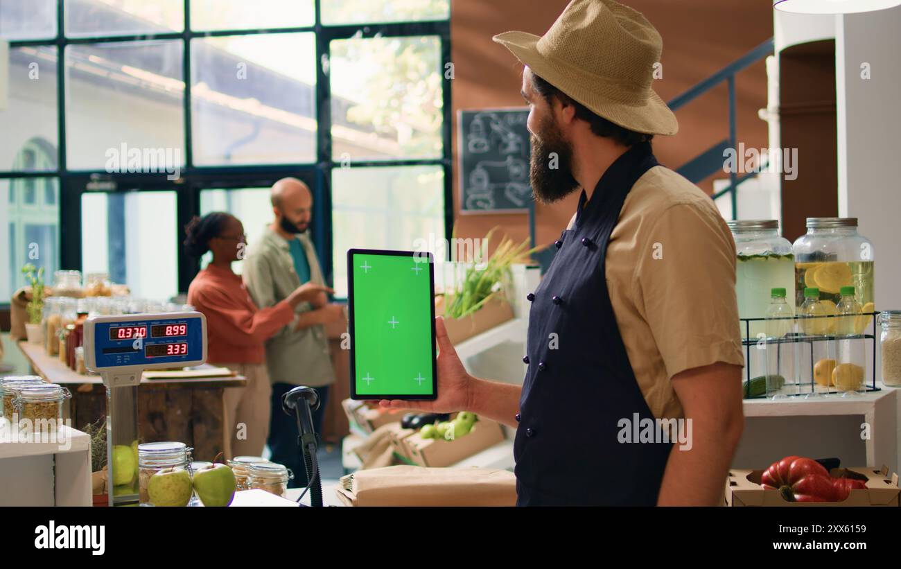 Farmer holding tablet with greenscreen in zero waste eco market, using ...
