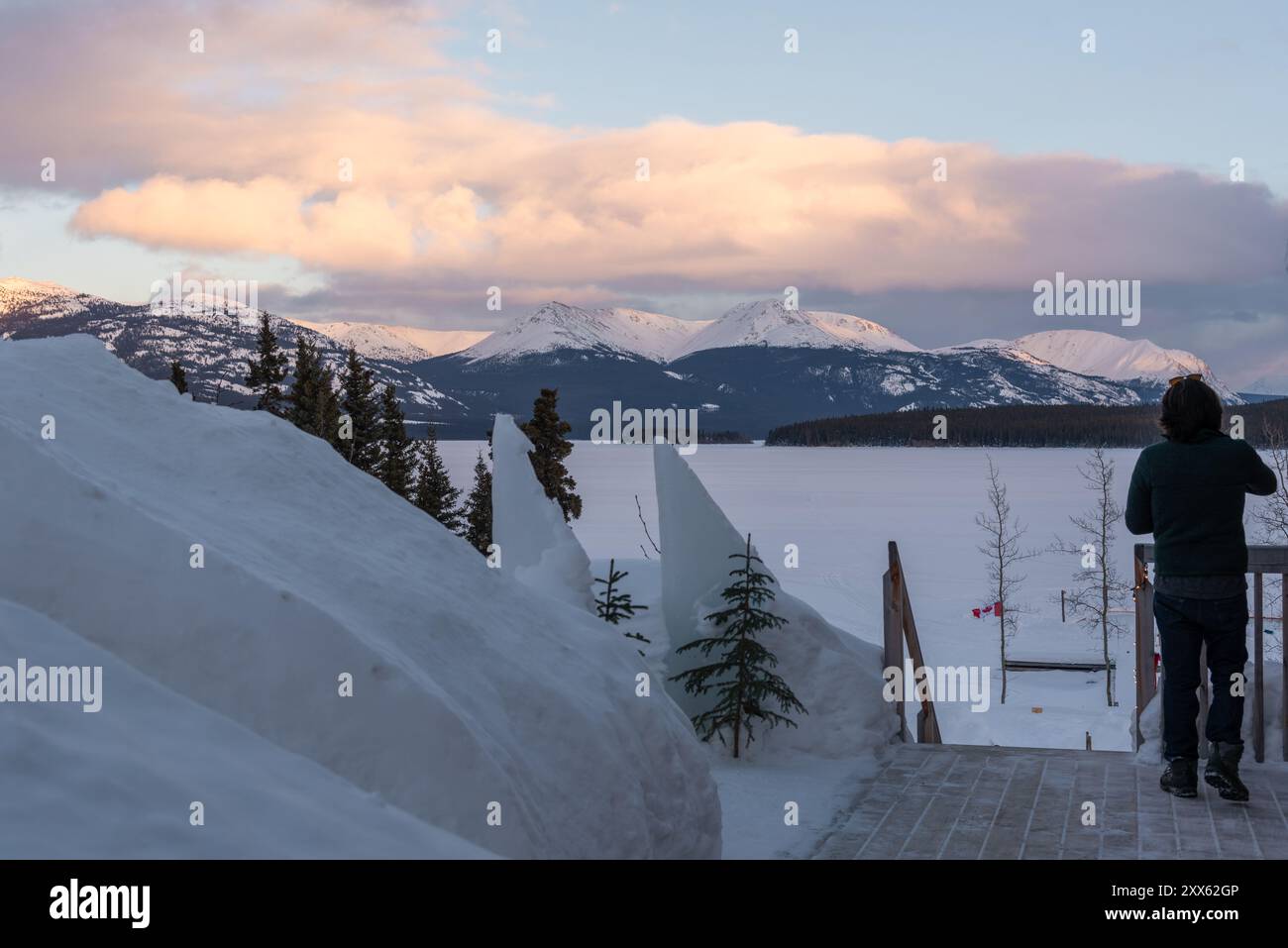 A man with brown hair taking photos of a mountain view scenic spot in ...