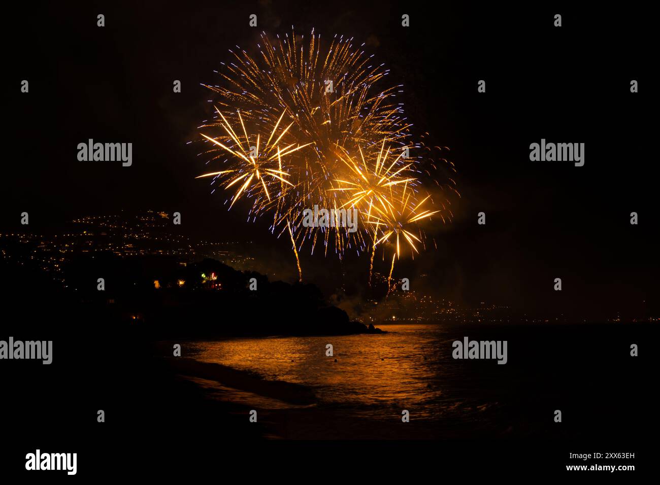 A stunning nighttime scene featuring bright yellow and orange fireworks ...