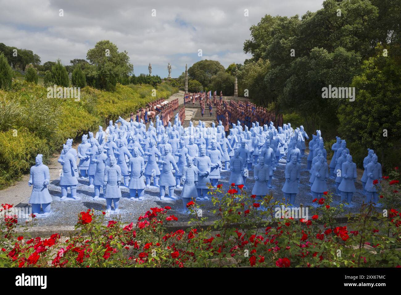 Numerous blue terracotta soldier statues stand on a path lined with ...