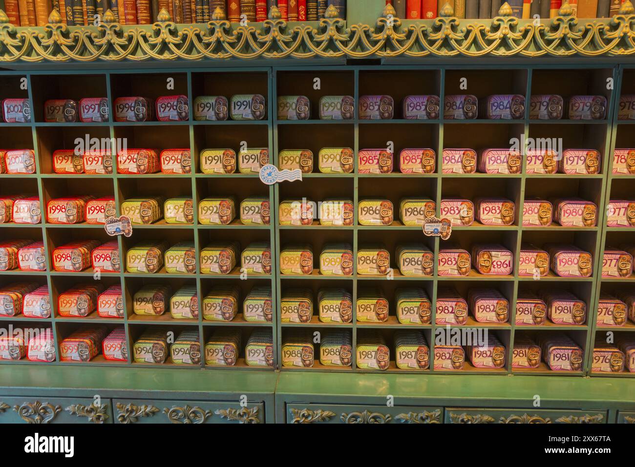 A shelf in the shop stocked with many tins of sardines in different ...