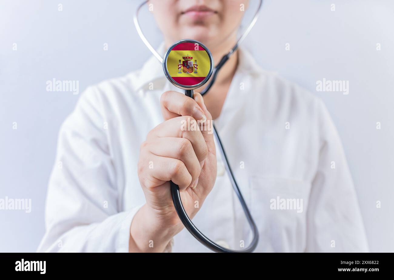 Female doctor holding stethoscope with Spain flag. Spanish Health and ...