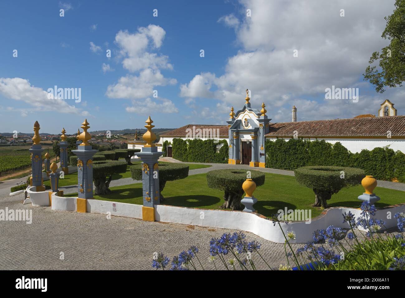 Traditional building in a well-kept garden with hedges and decorative ...