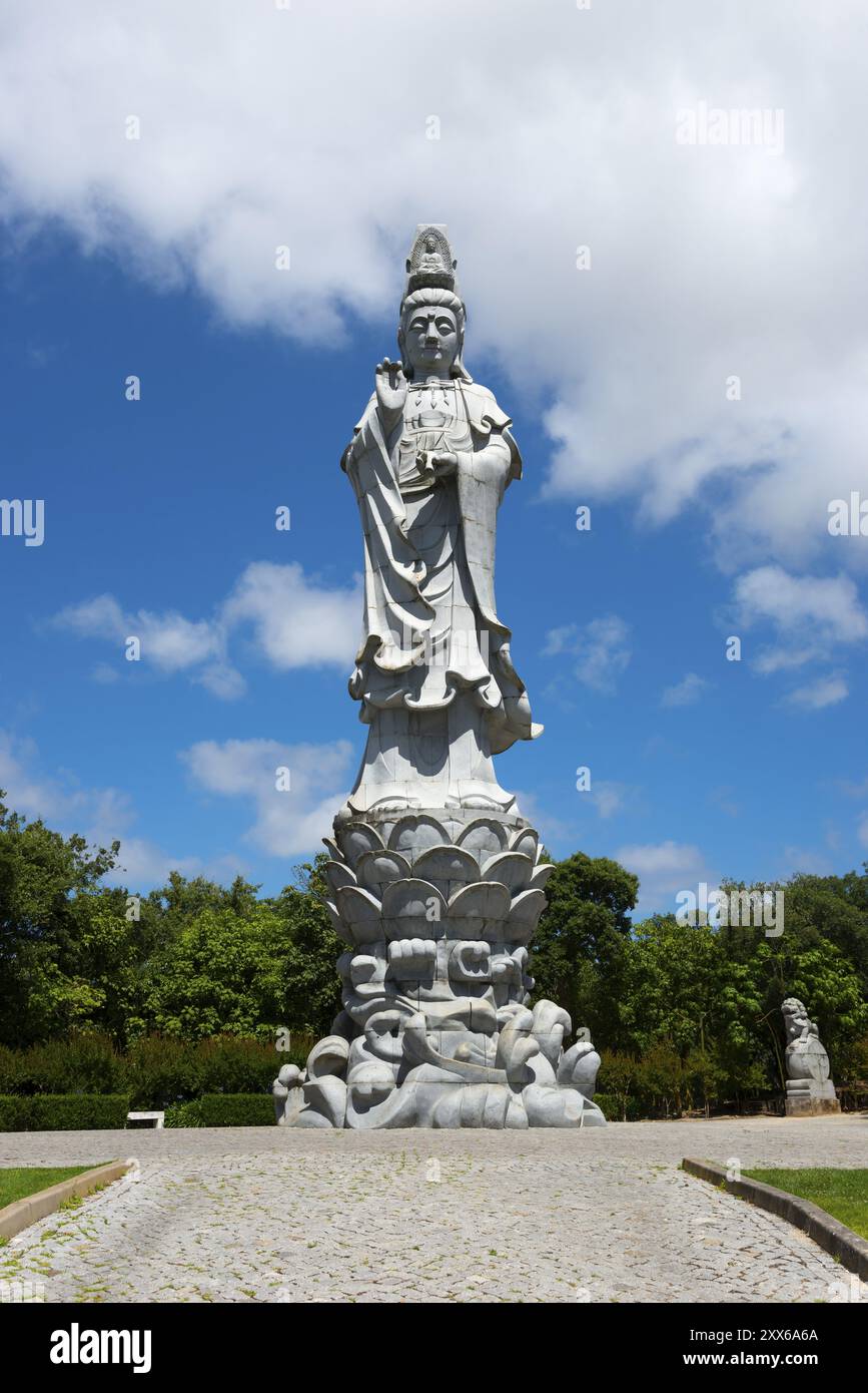Large stone statue of a majestic figure in front of a blue sky with ...