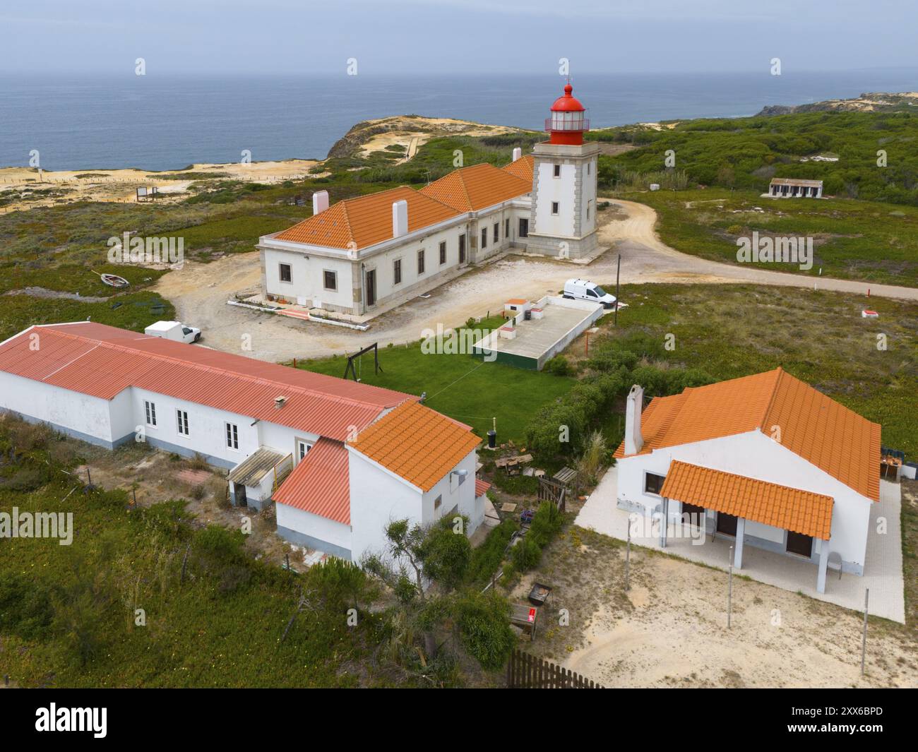 Aerial view of a lighthouse and neighbouring buildings on the coastline ...