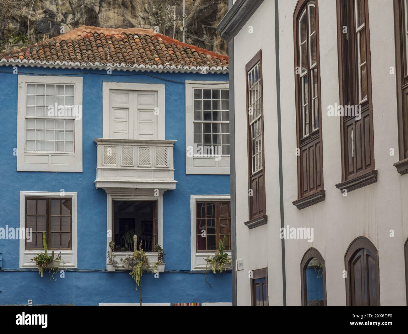 Blue-painted building with white windows and tiled roof in an old ...