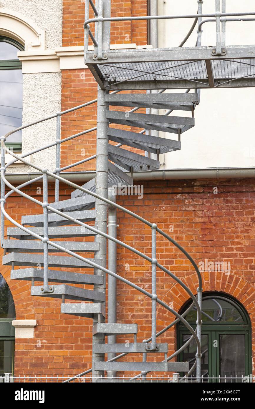 Metal spiral staircase on the brick facade of a refurbished industrial ...