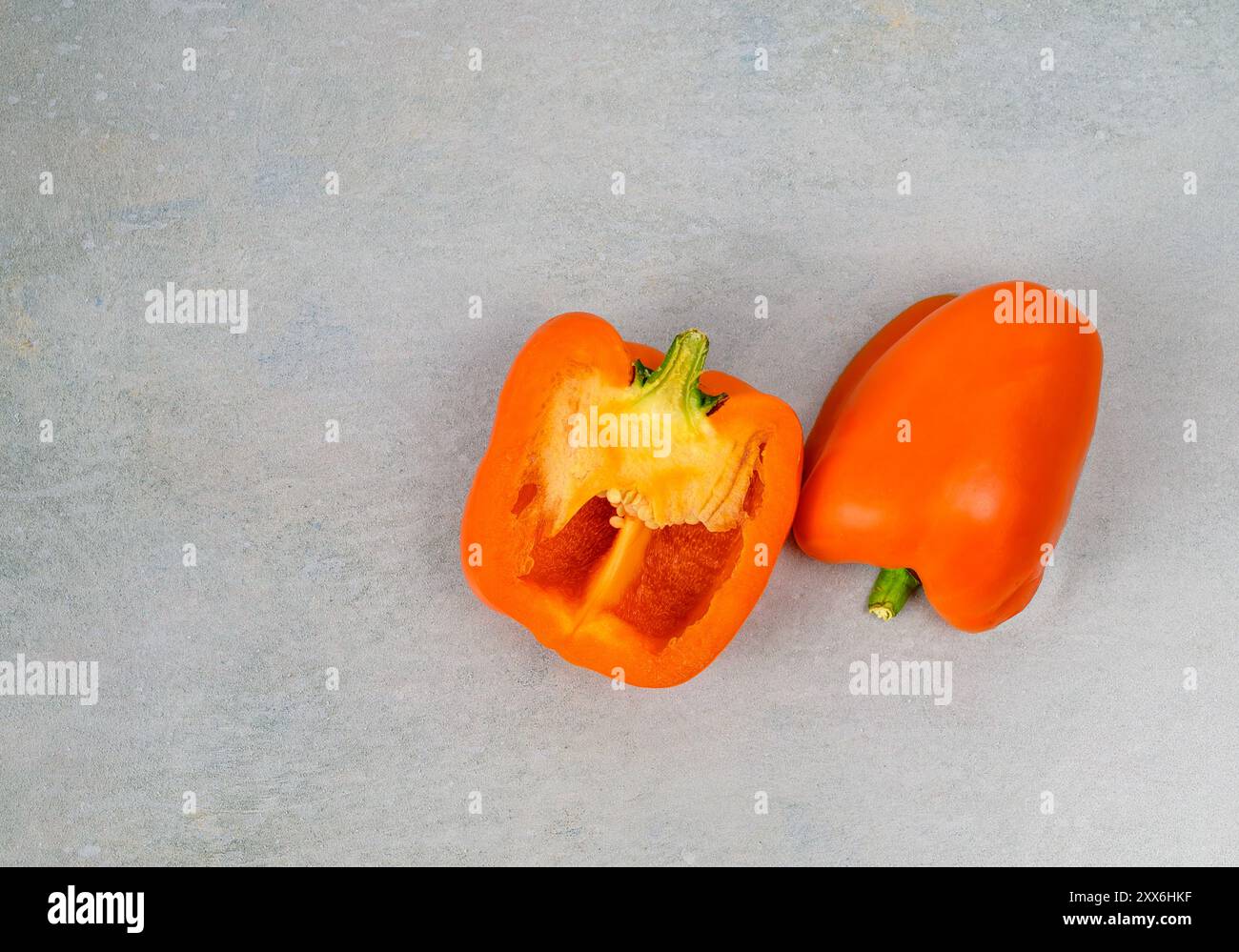 Orange bell pepper cut in half on blue tinted counter top Stock Photo ...