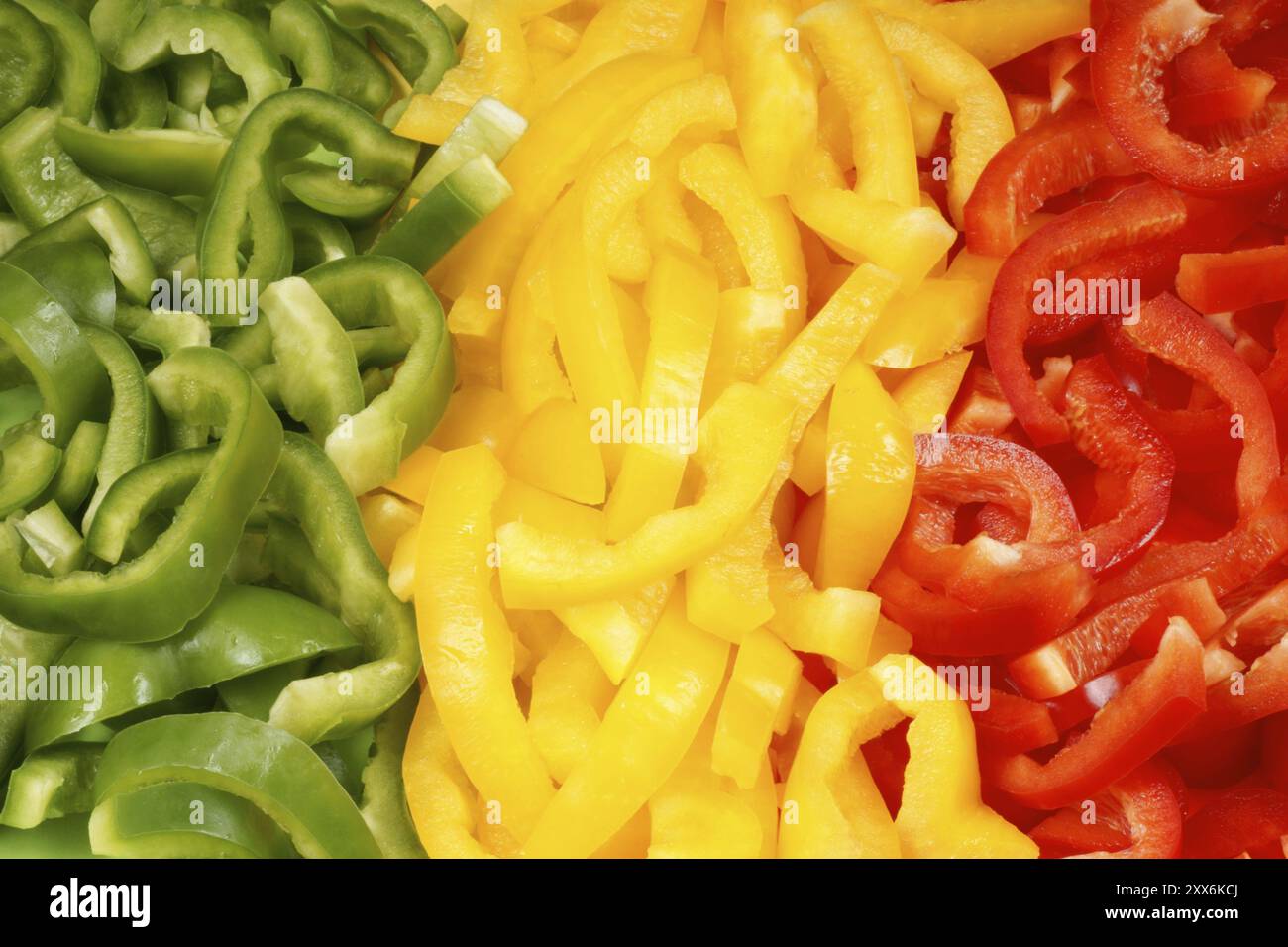 Organic background made of slices of green, yellow and red bell pepper ...