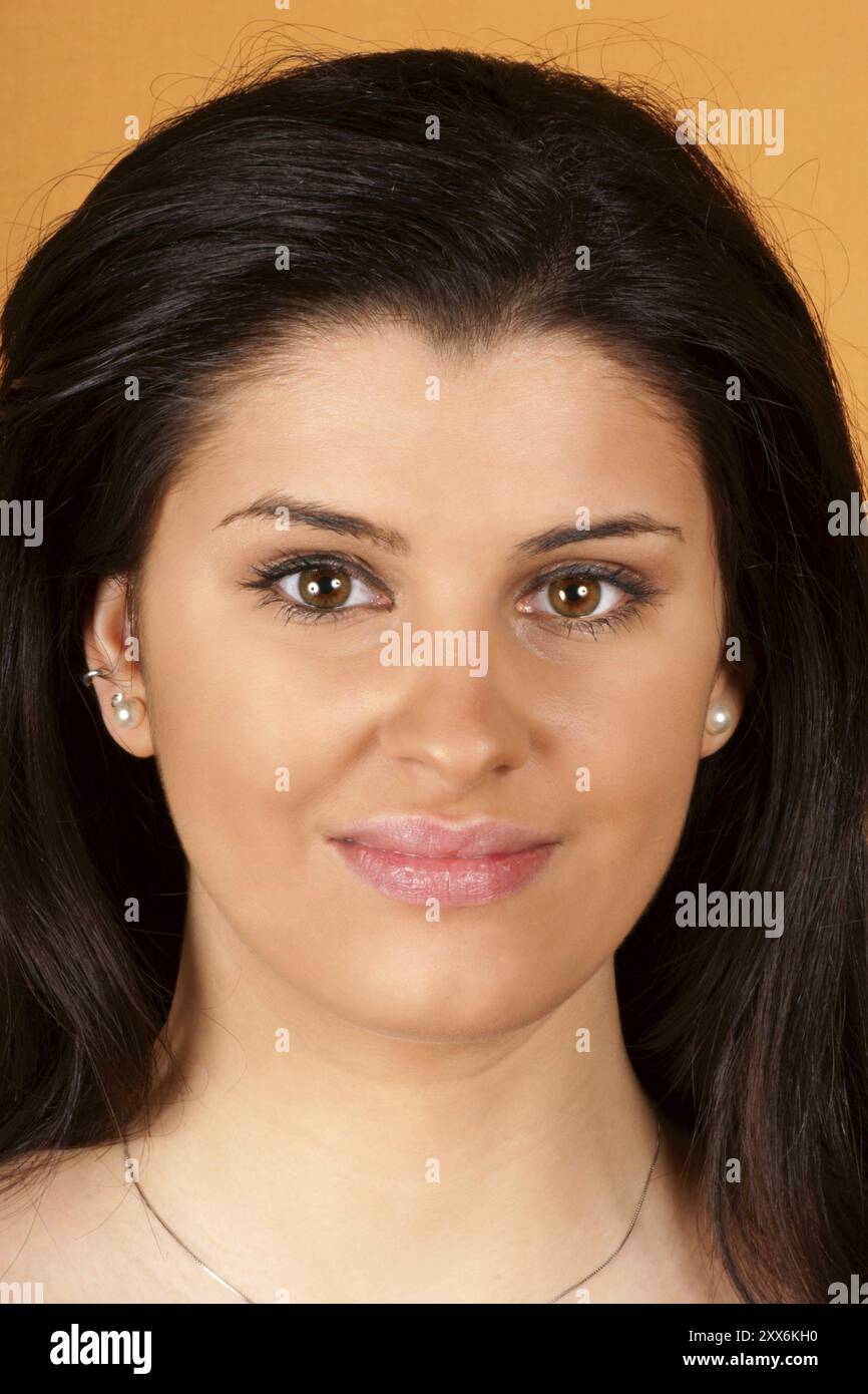 Beautiful 18 years old young woman portrait. Over an orange background ...