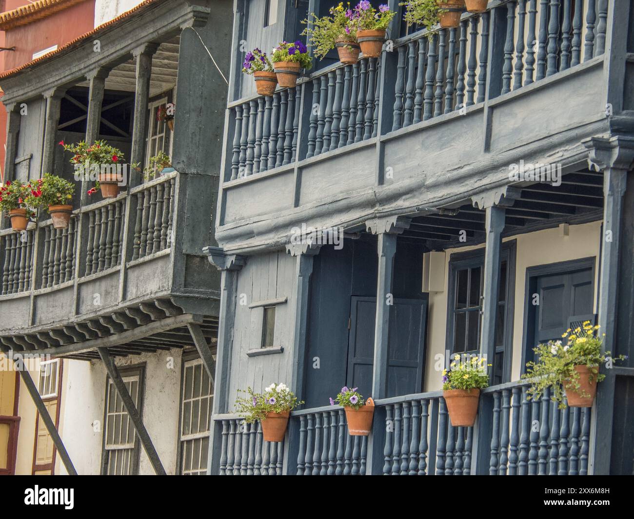 Multi-storey buildings with wooden balustrades and flower pots in front ...