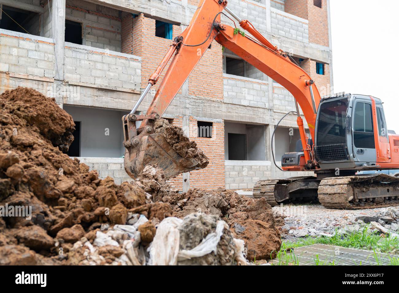 Excavator is digging the ground to embed septic tank in building site ...