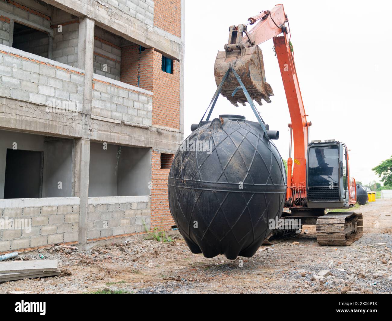 Excavator lifting septic tank Installation for sewage system in ...