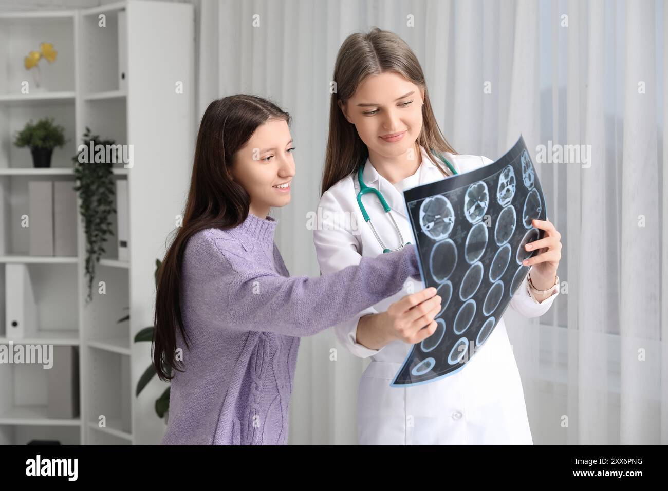 Beautiful doctor showing x-ray scan to patient in clinic Stock Photo ...