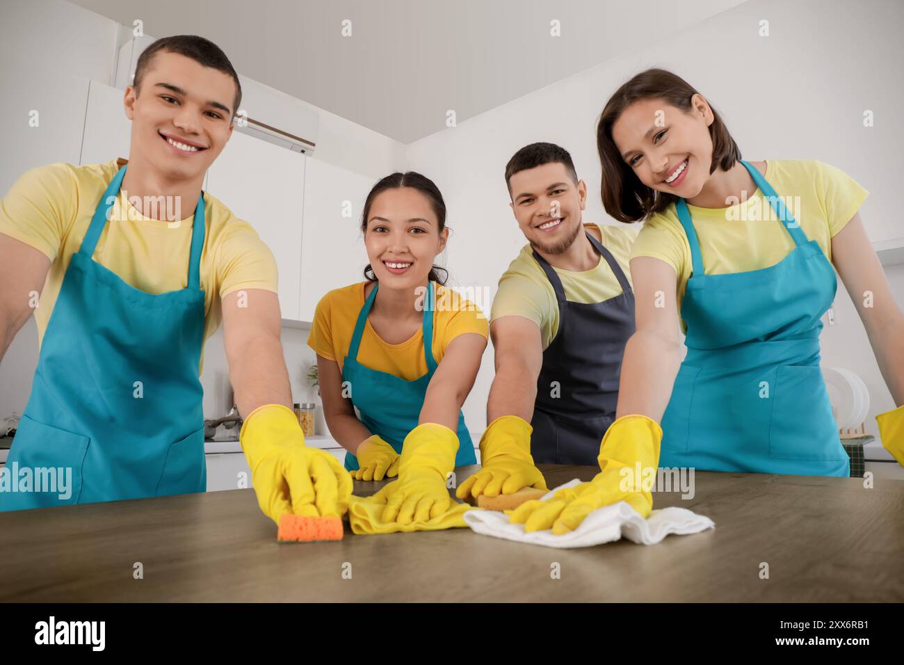 Group of young janitors cleaning table in kitchen Stock Photo - Alamy