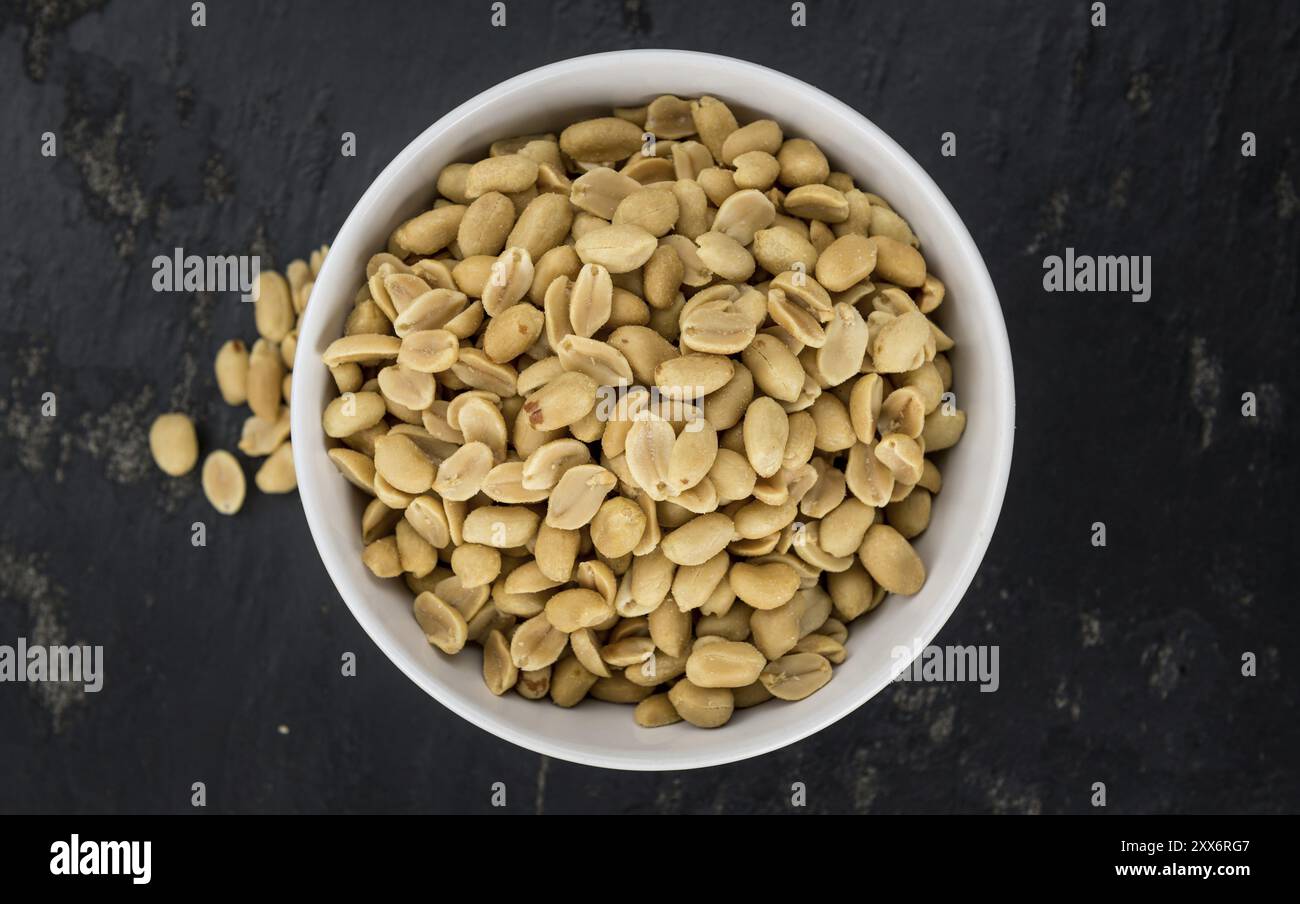 Roasted and salted Peanuts on vintage background (close-up shot ...
