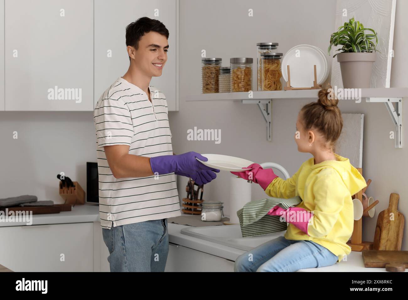 Young father and his daughter cleaning dishes together in kitchen Stock ...
