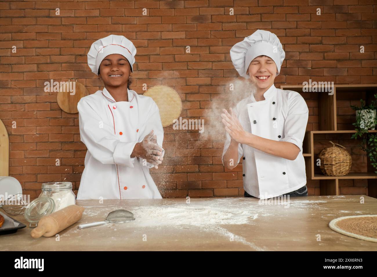 Teenage chefs playing with flour in kitchen Stock Photo - Alamy