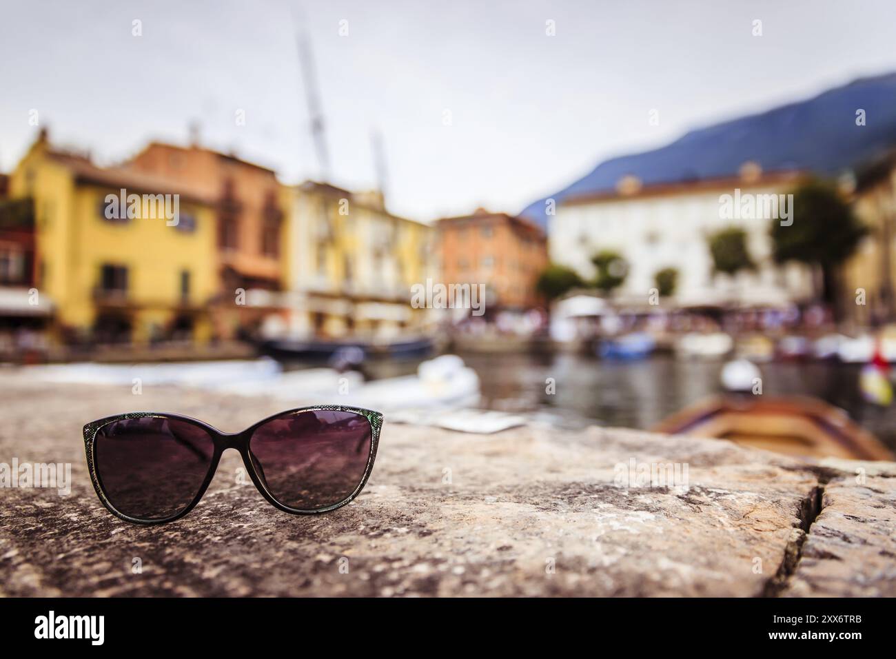 Italian harbour scene: Sunglasses on the stony ground Stock Photo - Alamy