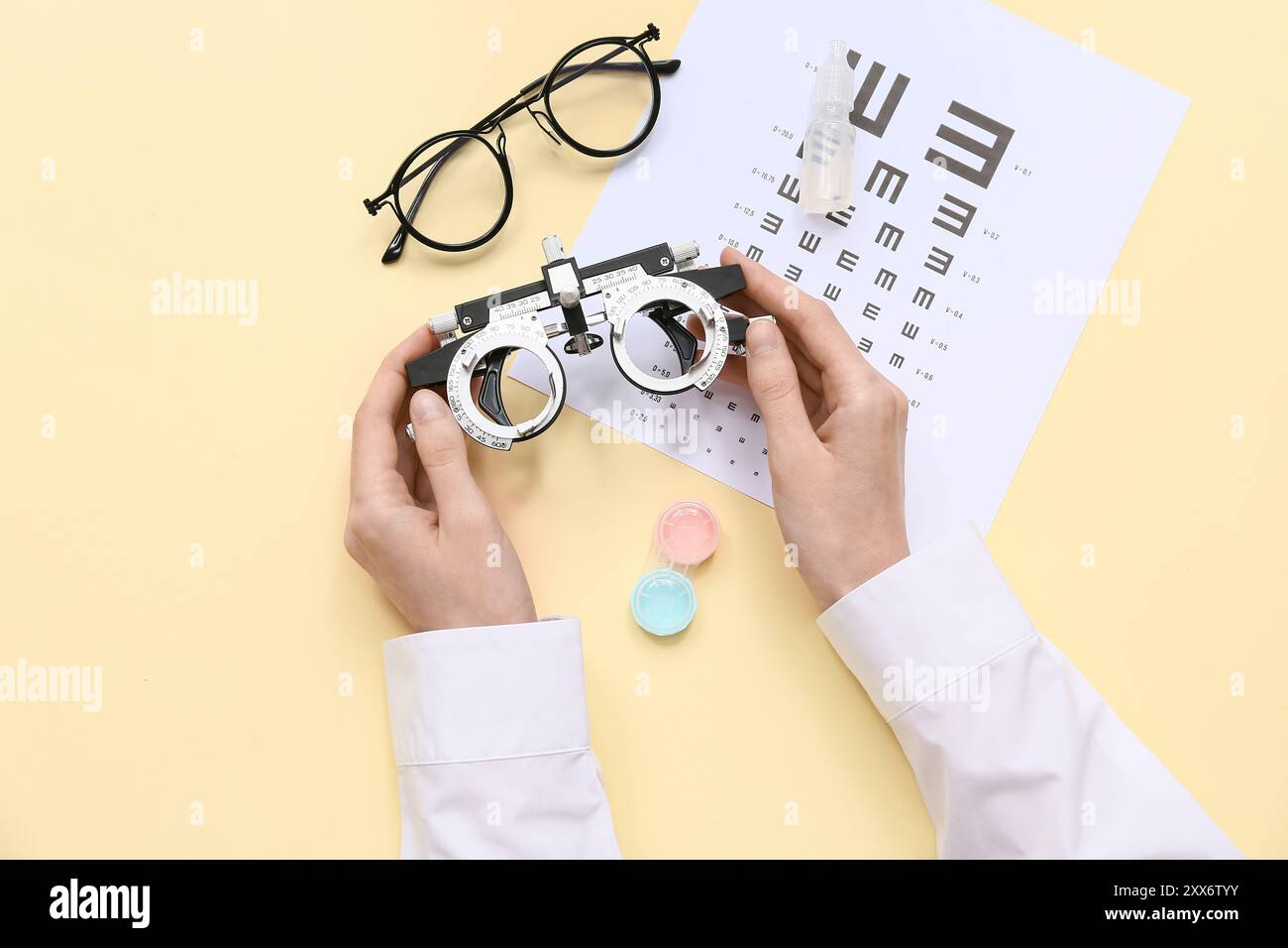 Doctor hands with optical trial frame, eye test chart and eyeglasses on ...