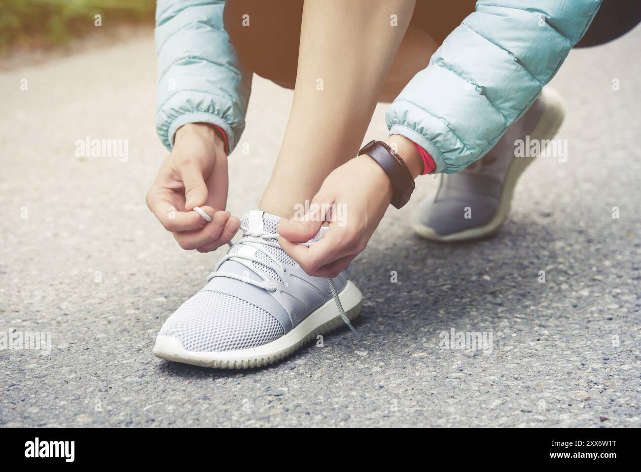 Girl runner tying laces for jogging her shoes on road in a park. Running shoes, Shoelaces ...