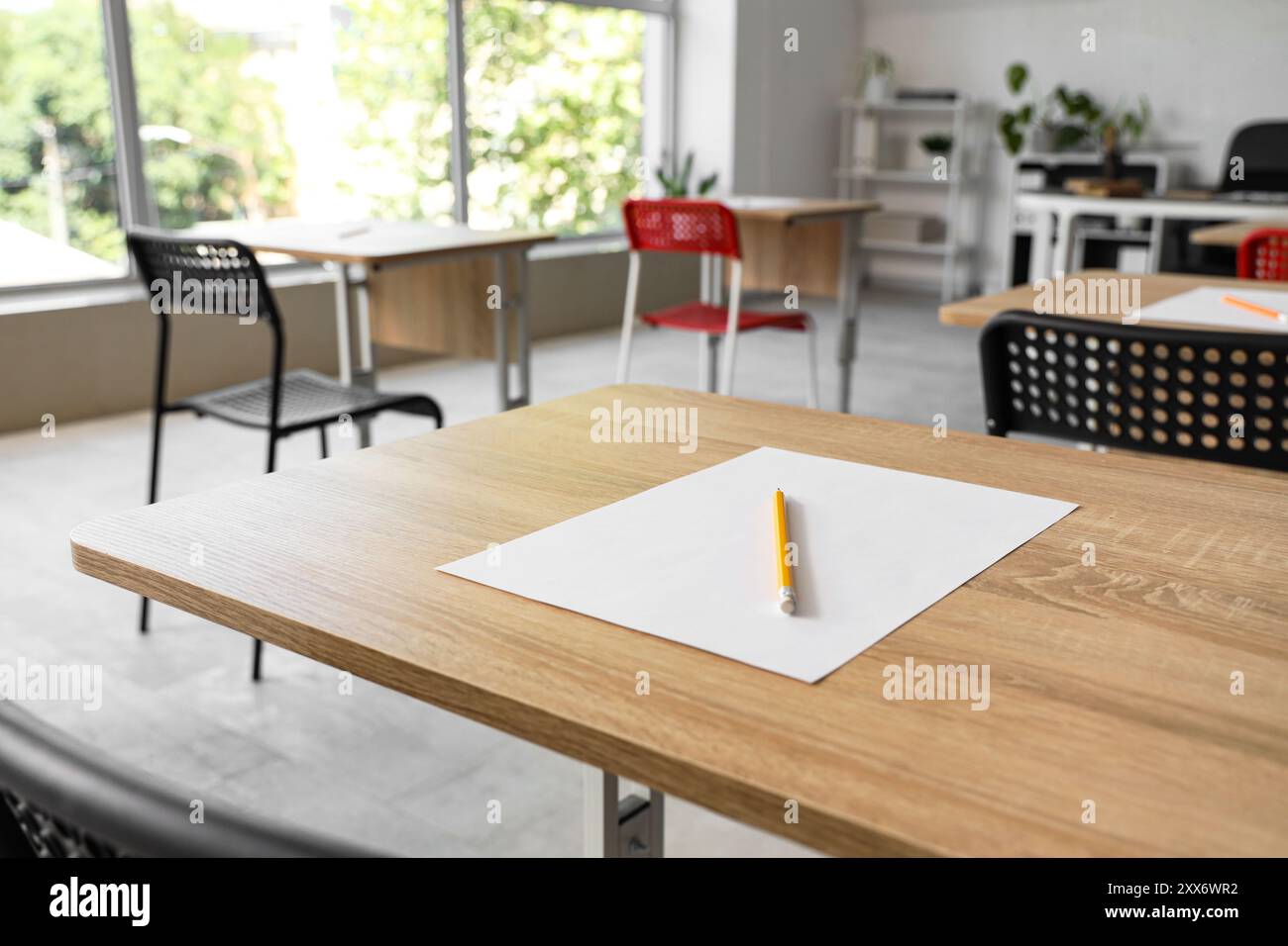 Desk with sheet of paper and pencil prepared for exam in classroom ...