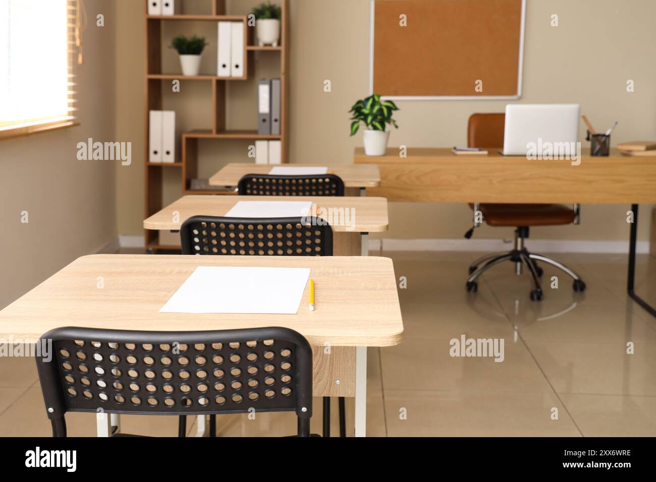 Desks with papers and chairs in empty classroom Stock Photo - Alamy