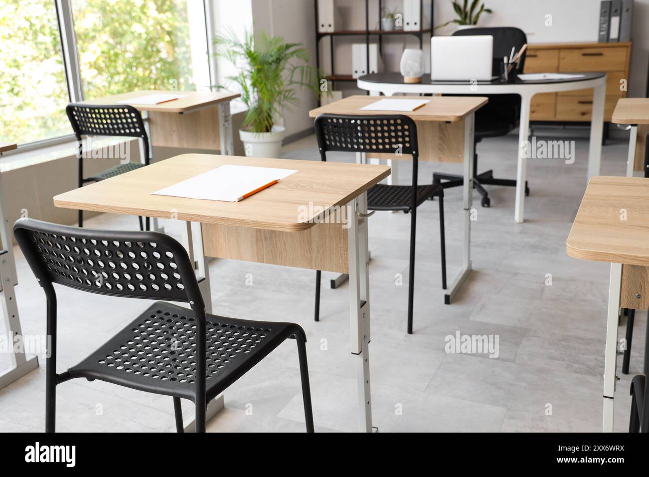 Desks with papers and chairs in modern empty classroom Stock Photo - Alamy