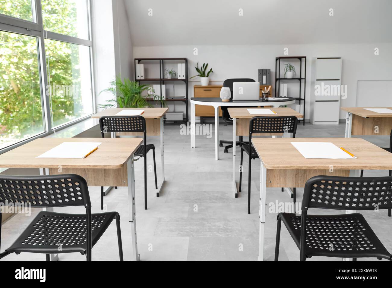 Desks with papers and chairs in modern empty classroom Stock Photo - Alamy
