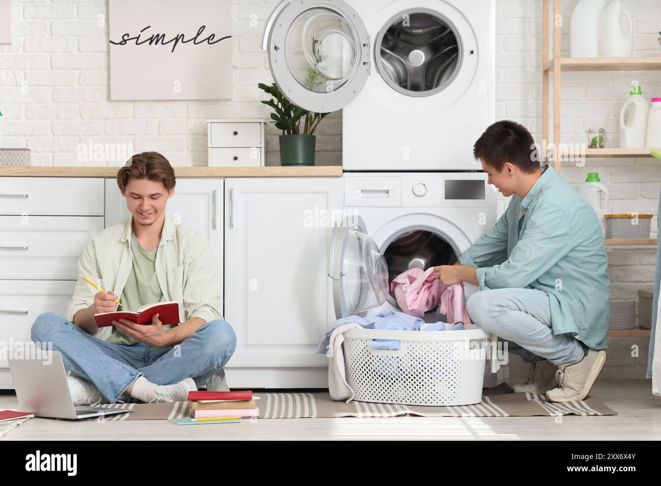 Male students studying in dorm laundry room Stock Photo - Alamy