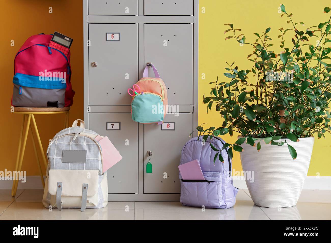 Locker with school backpacks near yellow wall Stock Photo - Alamy
