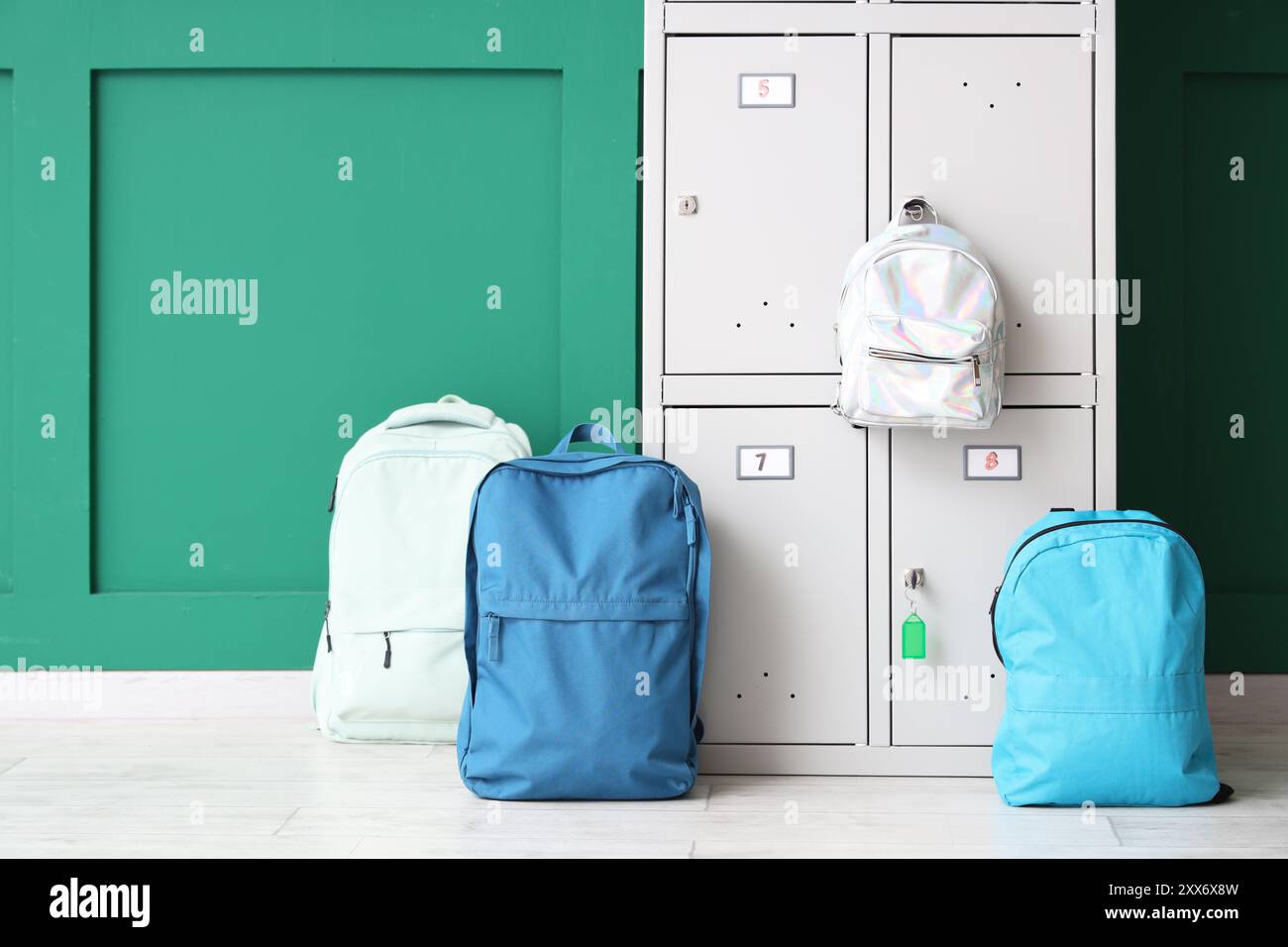 Locker with school backpacks near green wall Stock Photo - Alamy
